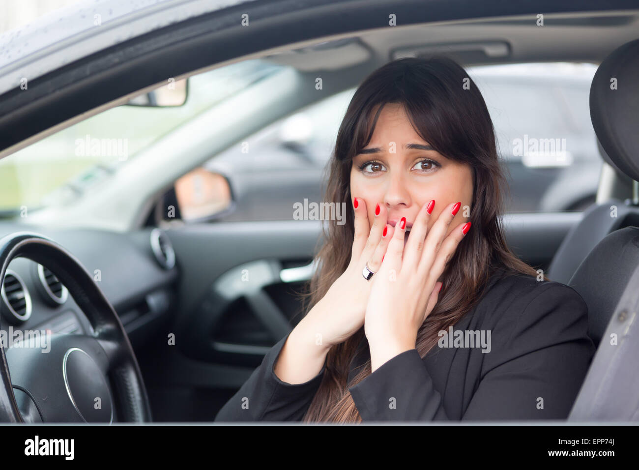 Woman in panic after having a car crash Stock Photo - Alamy
