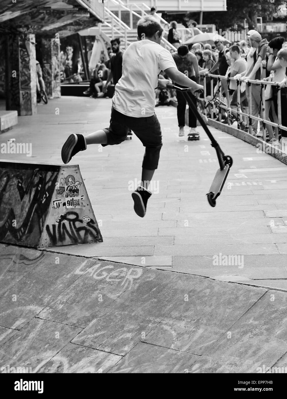 Teenager doing jump on scooter Stock Photo - Alamy