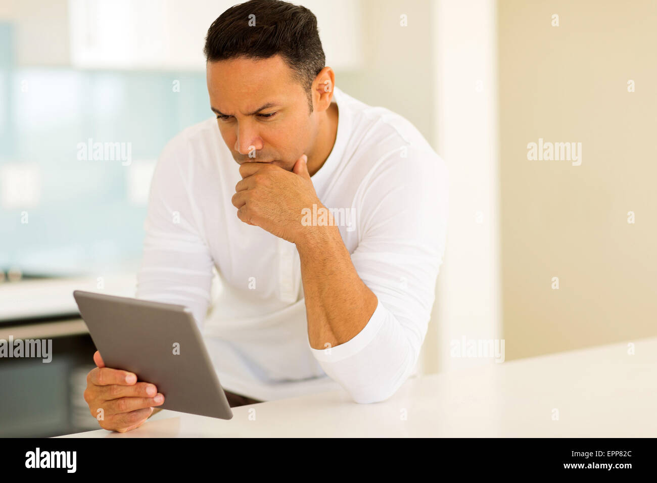 thoughtful middle aged man using tablet pc at home Stock Photo - Alamy