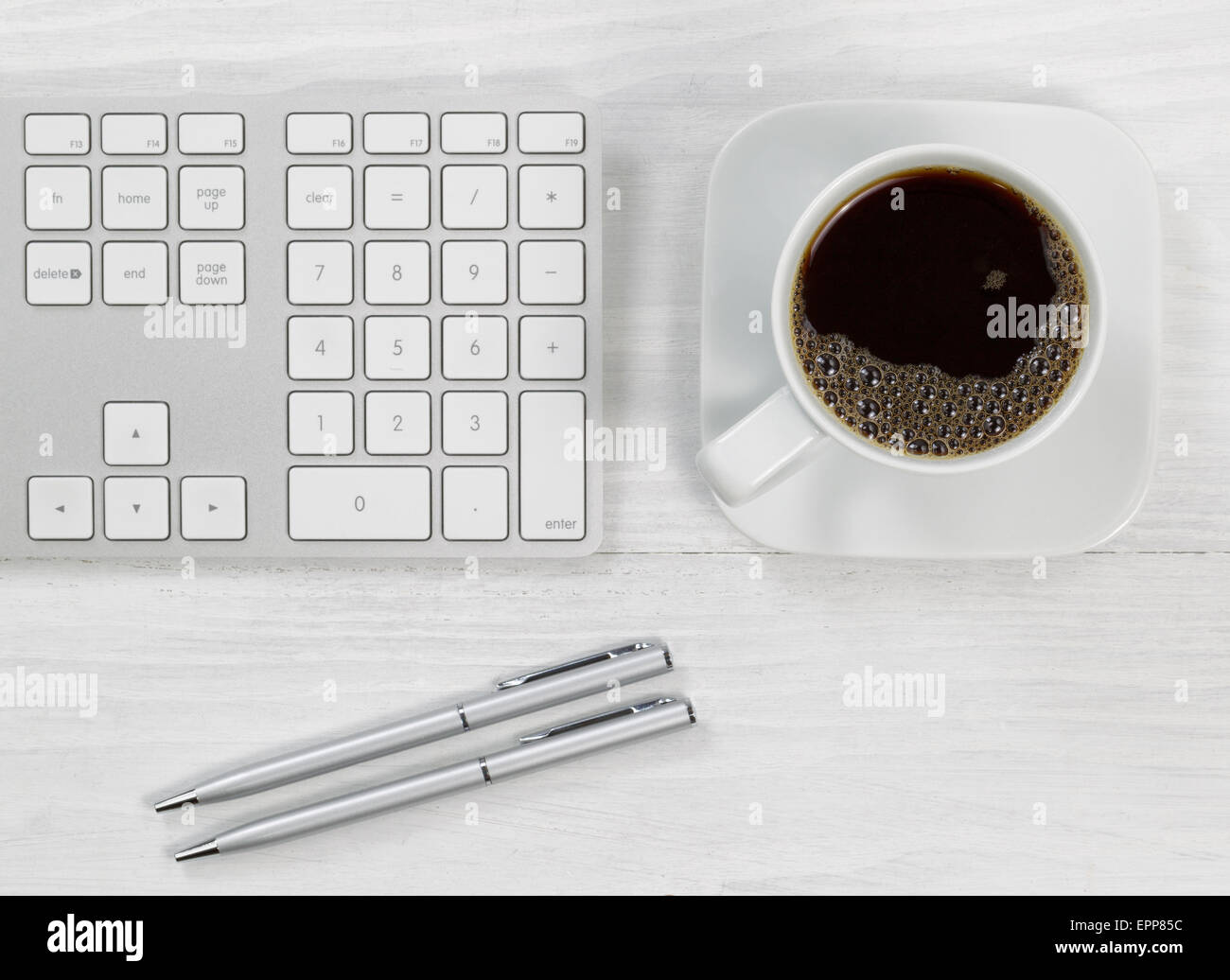 Cup of coffee, focus on top part of coffee, computer keyboard and ink ...