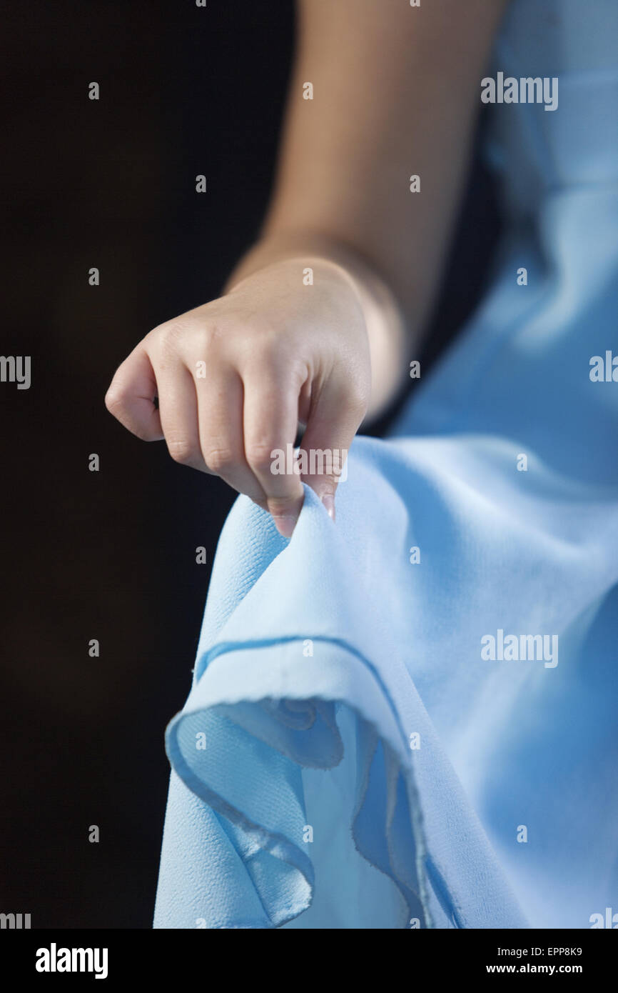Close up of a young girls hand holding her dress up Stock Photo - Alamy