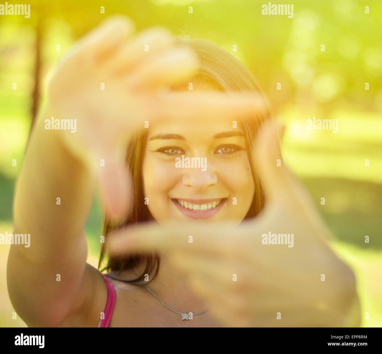 Beautiful girl making frame with hands while outdoors Stock Photo - Alamy