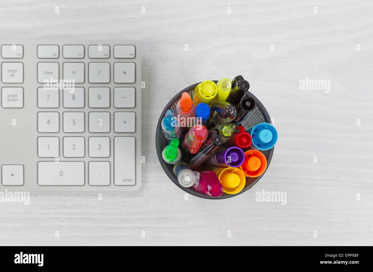 Container of pens and markers, focus top of container, and computer ...
