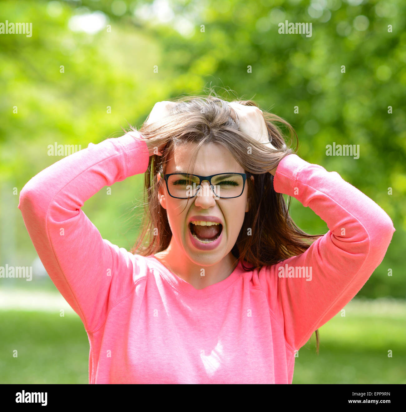 Scream - Beautiful young woman screaming and pulling hair outdoors ...