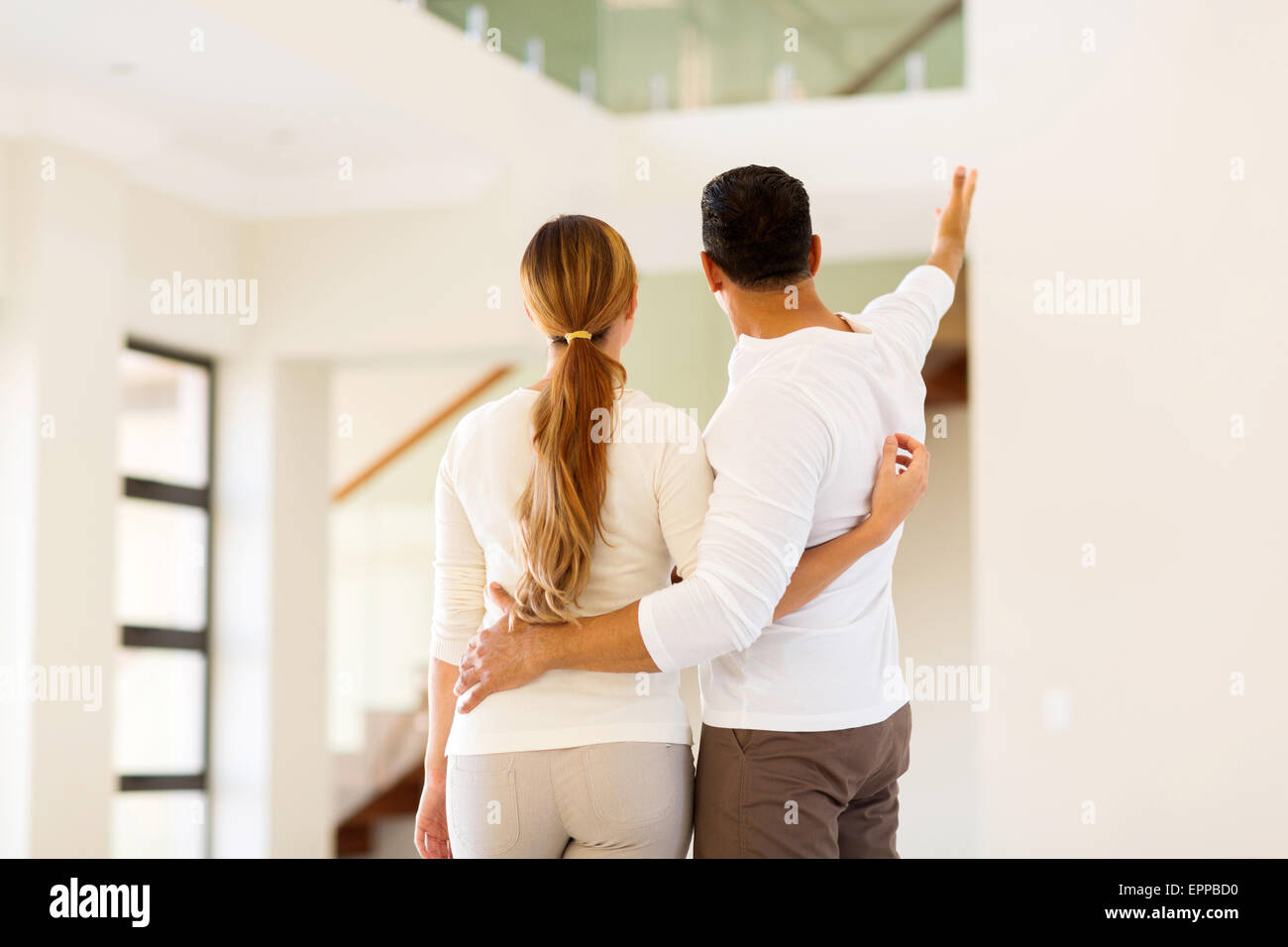 rear view of couple looking around their new home Stock Photo - Alamy