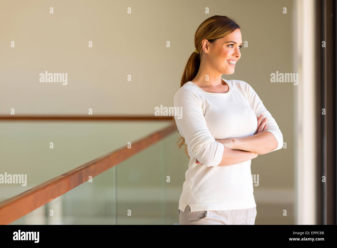attractive young woman looking outside window Stock Photo - Alamy