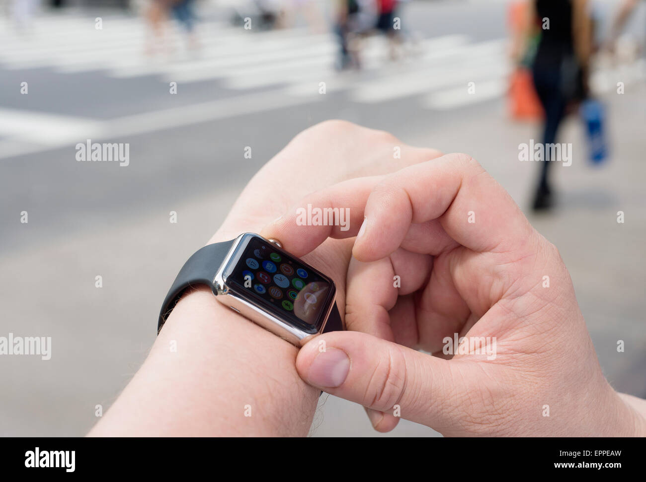 A man using an apple watch on an intersection in NYC Stock Photo - Alamy