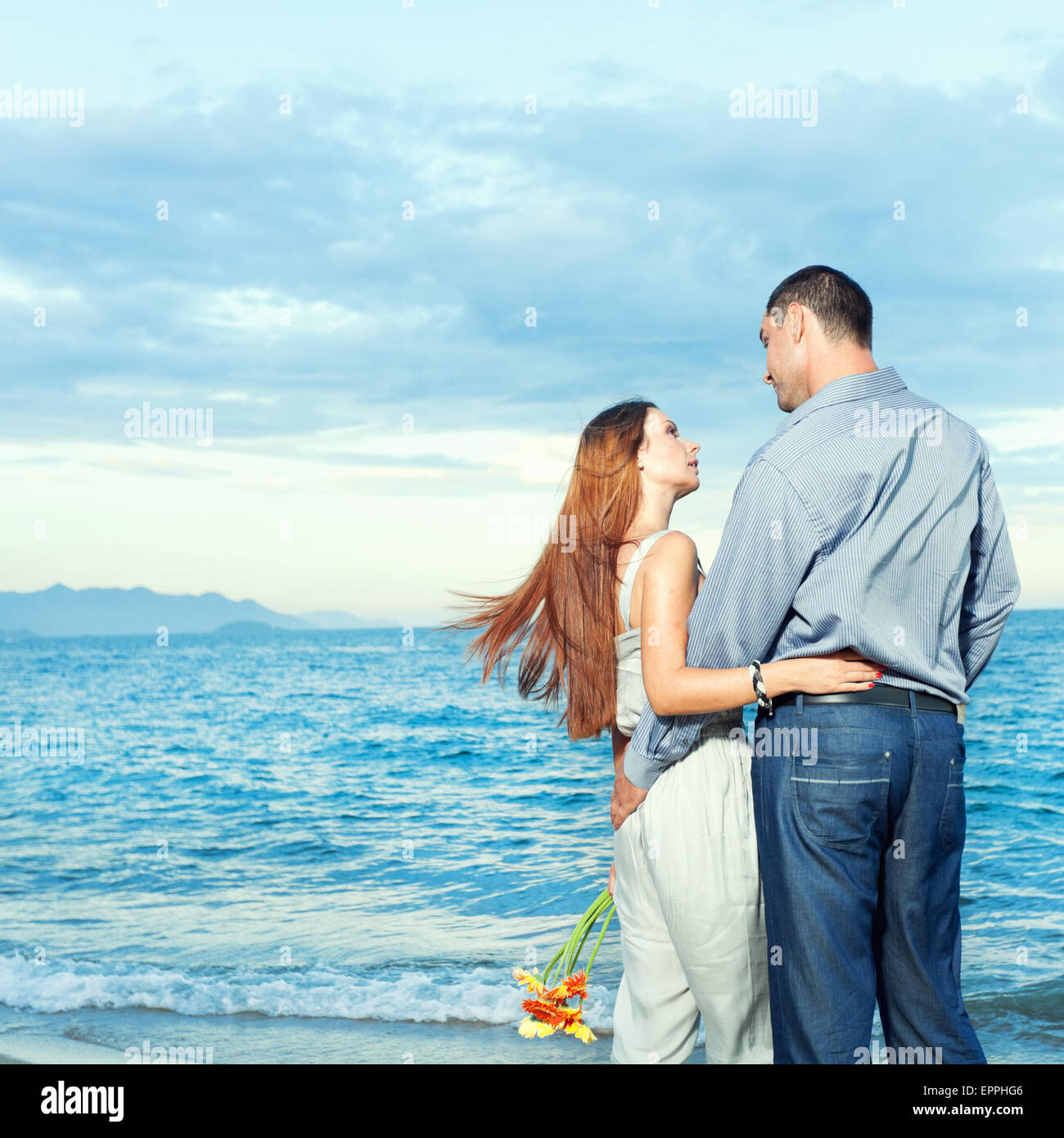 Young beautiful couple staying near the ocean Stock Photo - Alamy
