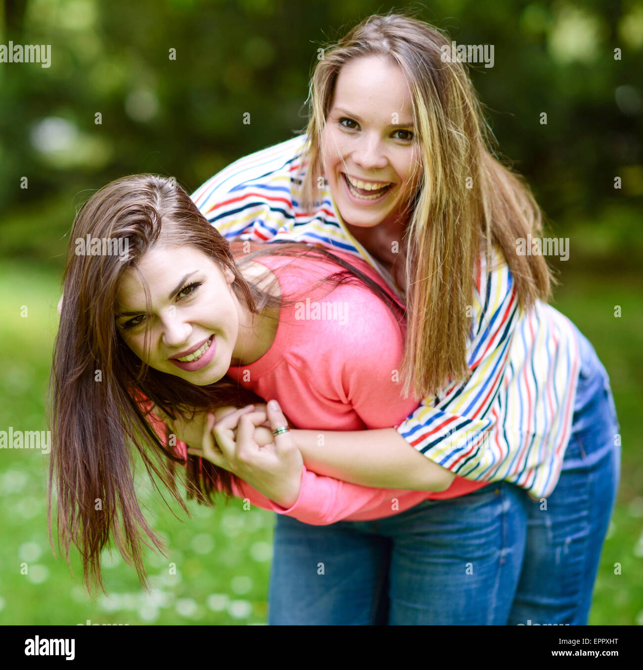 Two young girl friends in a hug at park Stock Photo - Alamy