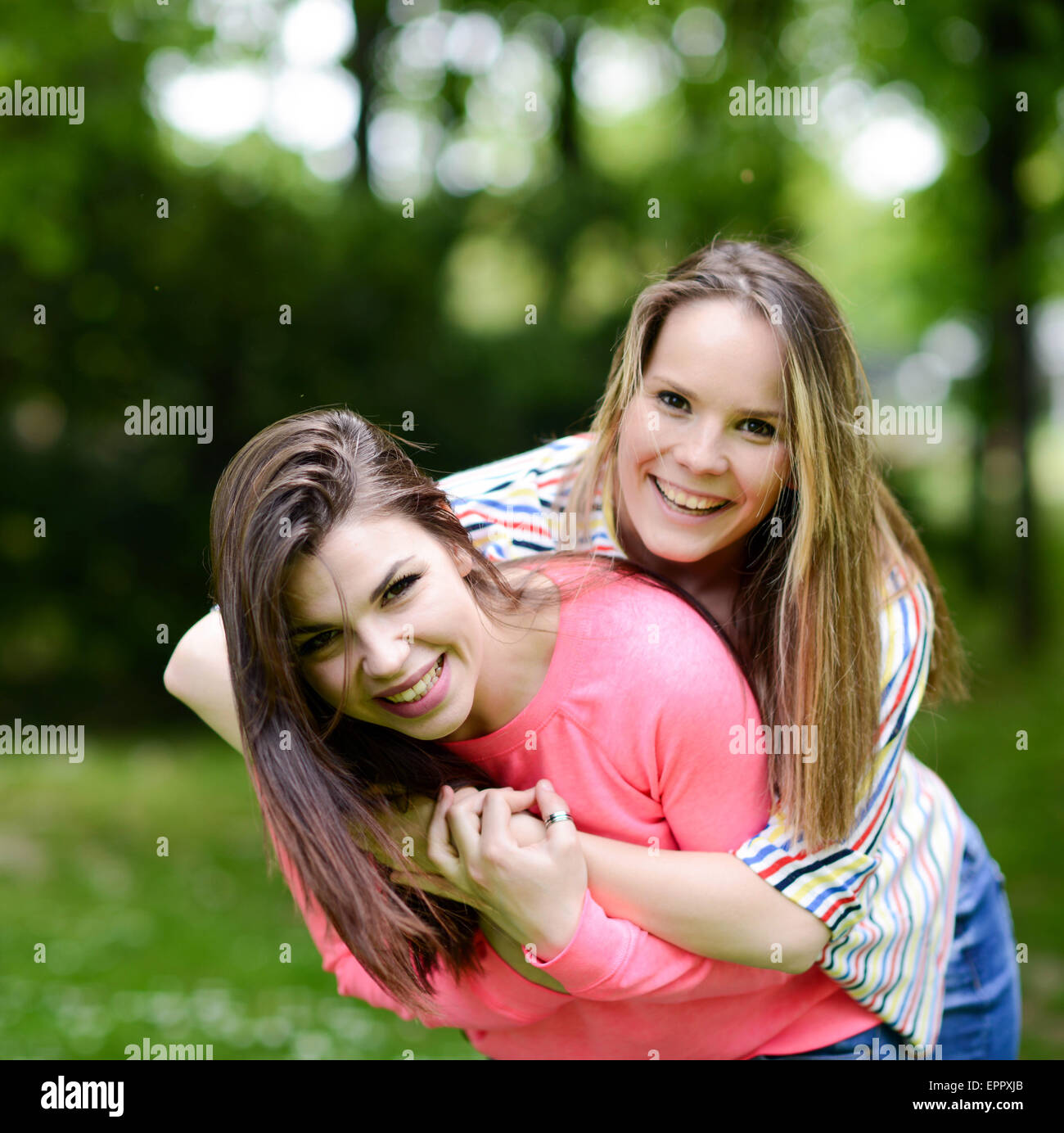 Two young girl friends in a hug at park Stock Photo - Alamy