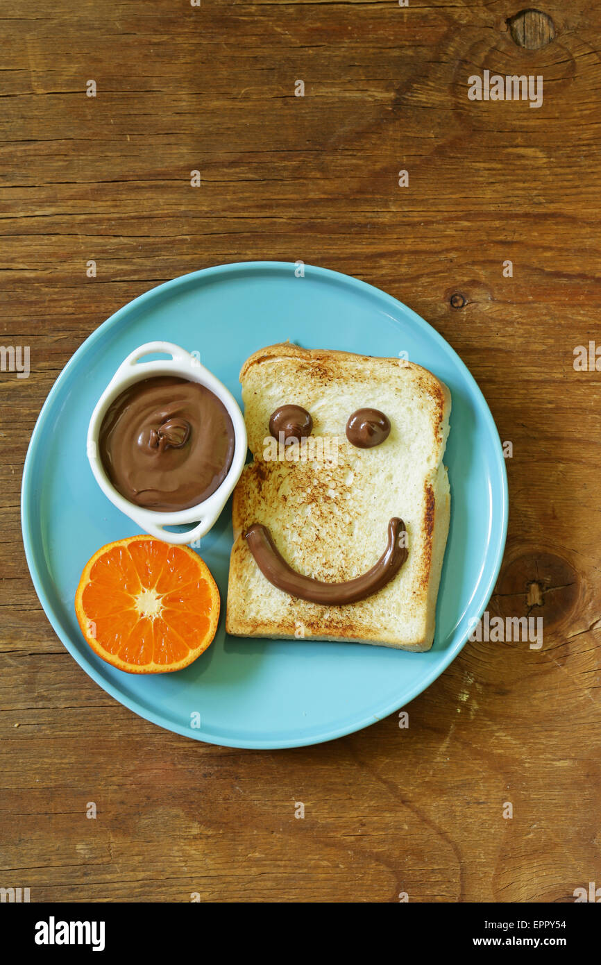 breakfast serving funny face on the plate (toast, chocolate spread and ...