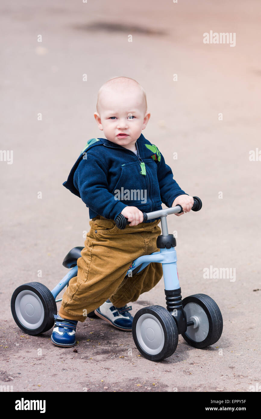 Cute baby boy learnign to ride his first running bike in a park Stock ...