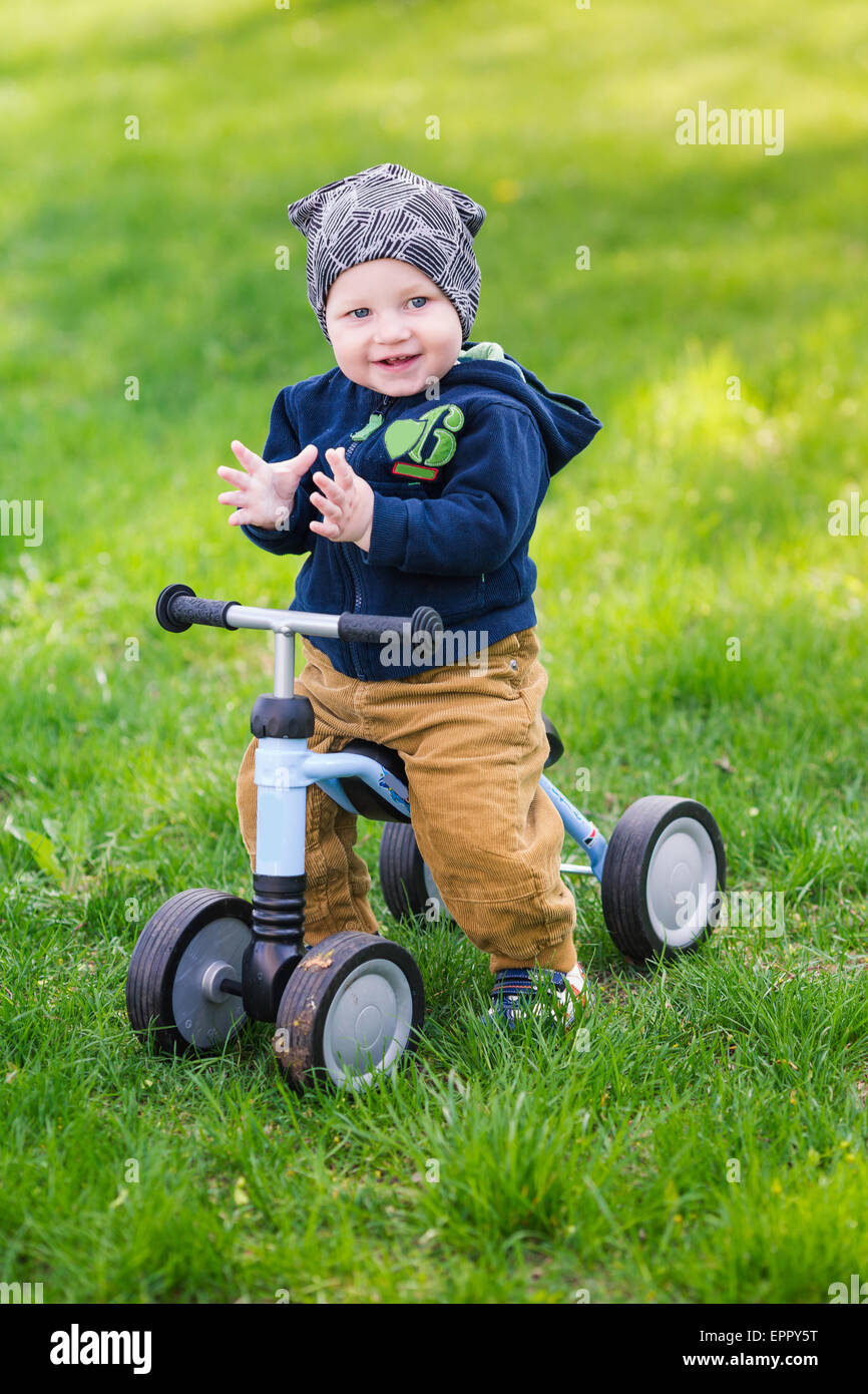 Cute baby boy learnign to ride his first running bike in a park Stock ...