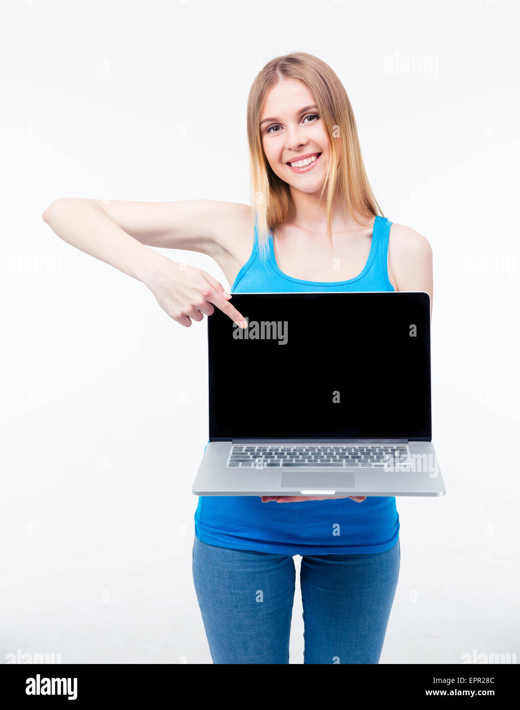 Smiling young woman pointing finger on the blank laptop screen isolated ...