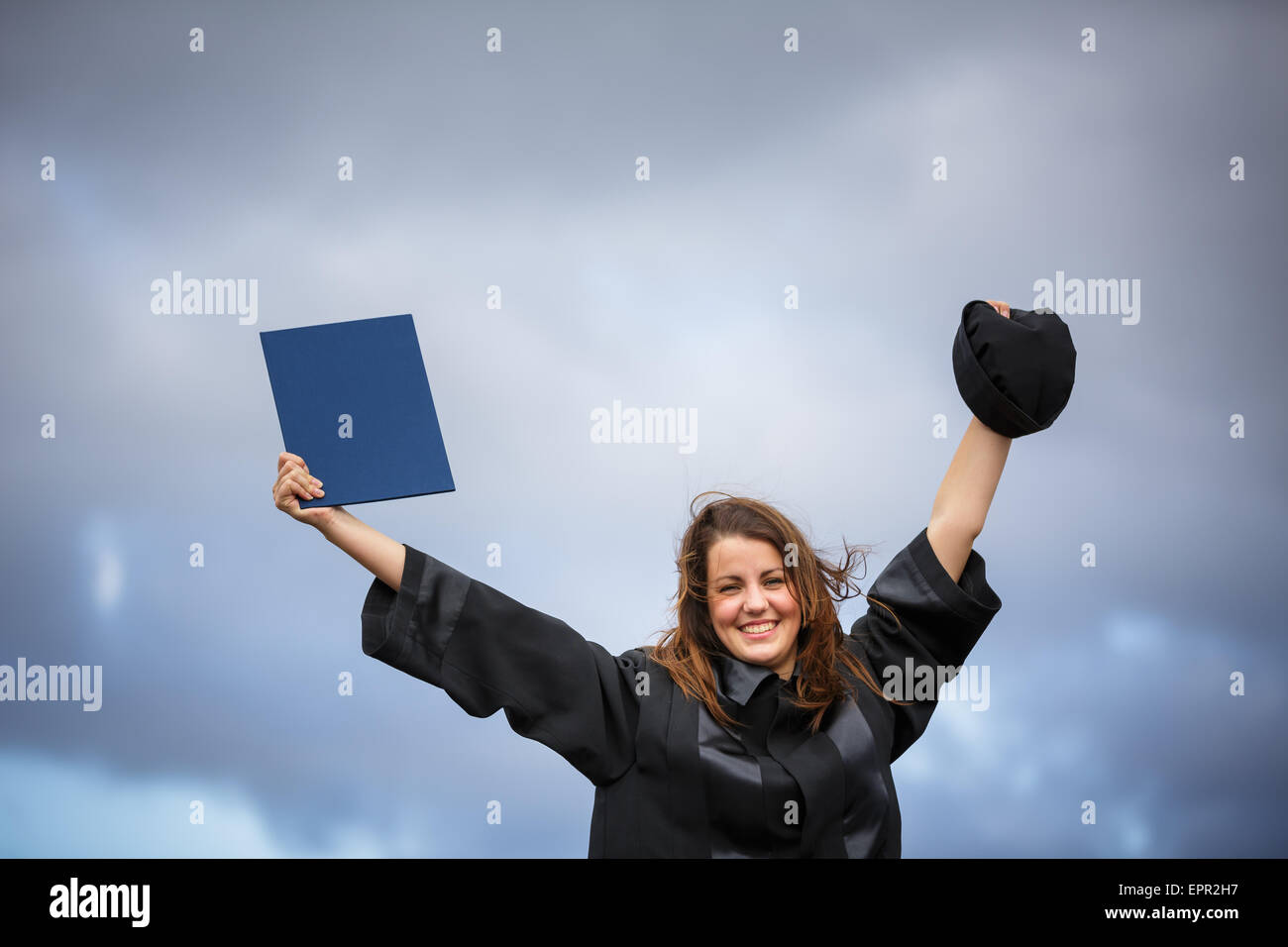 Pretty, young woman celebrating joyfully her graduation - spreading ...