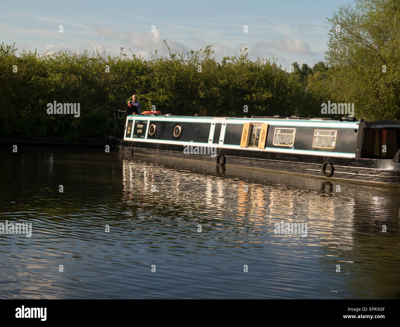 a narrow boat turns round in a winding hole on The Trent & Mersey canal ...