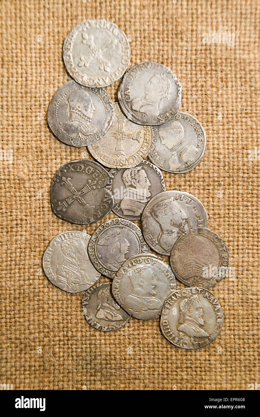 A lot of old silver coins with portraits of kings on the old cloth ...