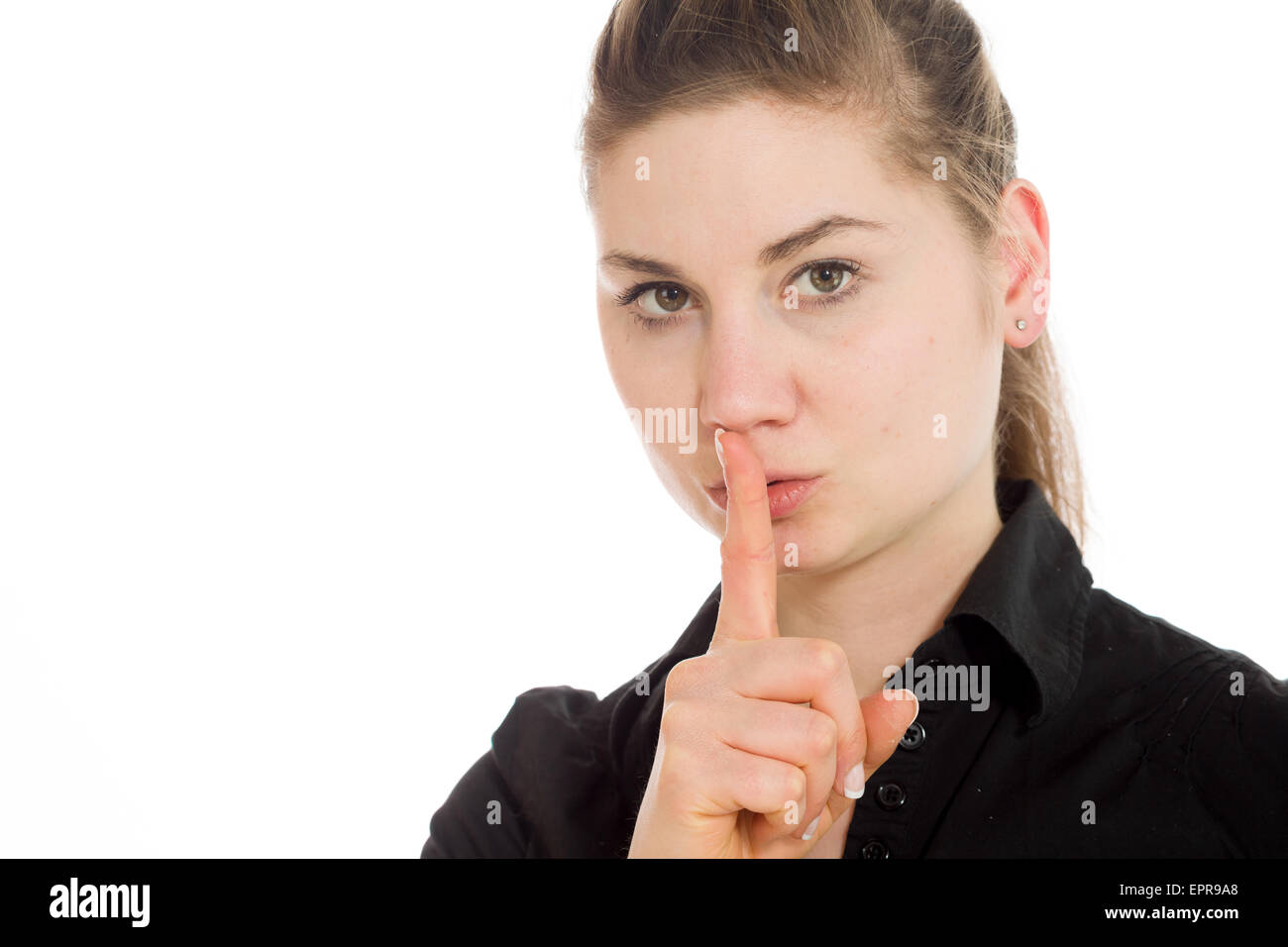 Model isolated on plain background in studio fingers on lips with ...