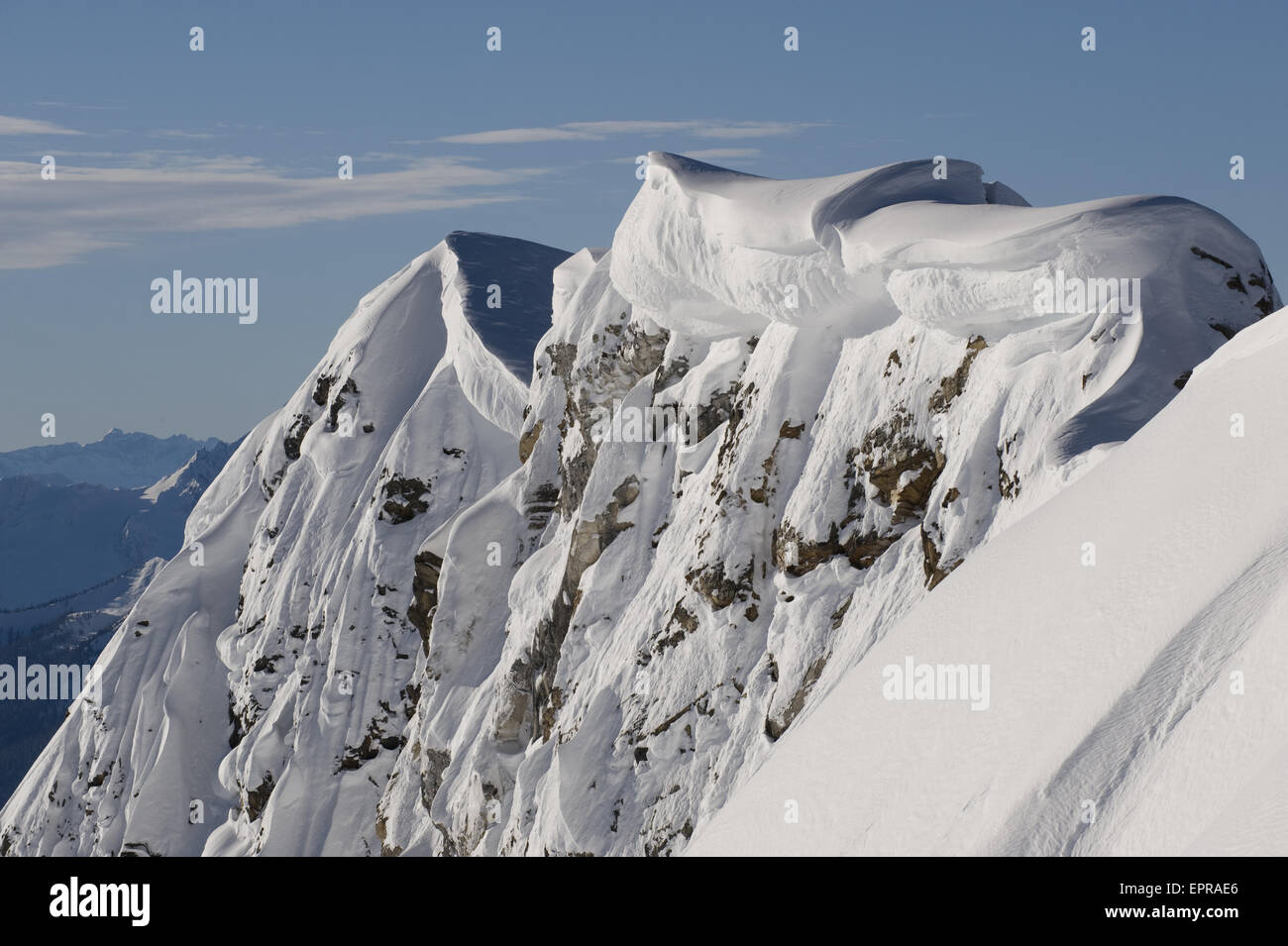 A mountain ridge holds heavy cornices from winter storms Stock Photo ...
