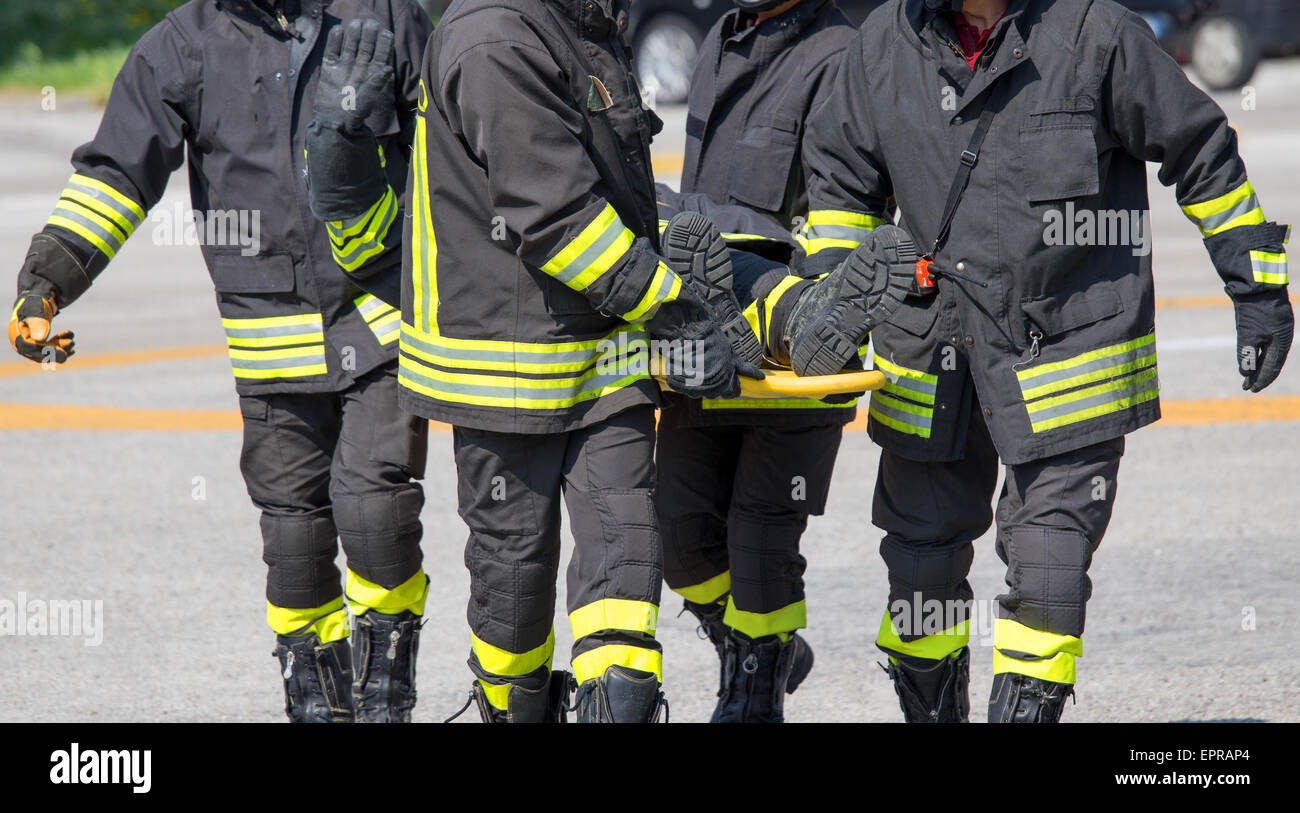 Four brave Firefighters carry a firefighter with the medical stretcher ...