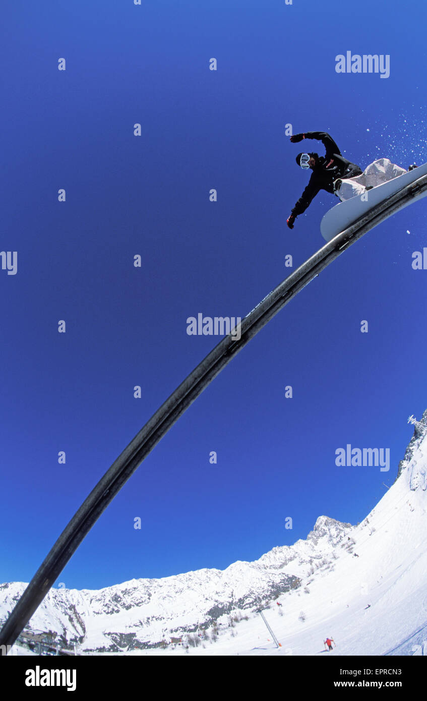 A young man rides a rail on his snowboard Stock Photo - Alamy
