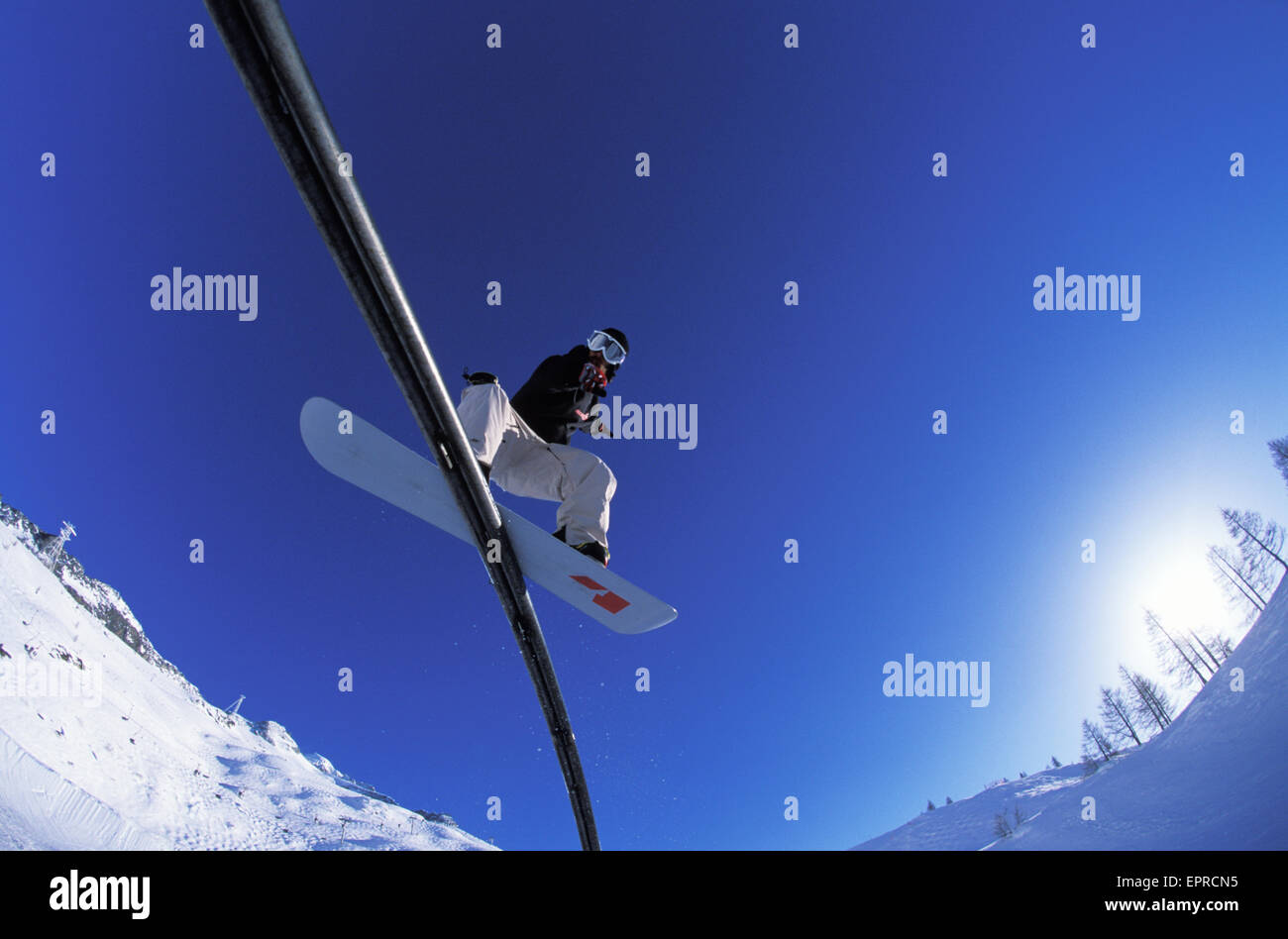 A young man slides a rail on his snowboard Stock Photo - Alamy