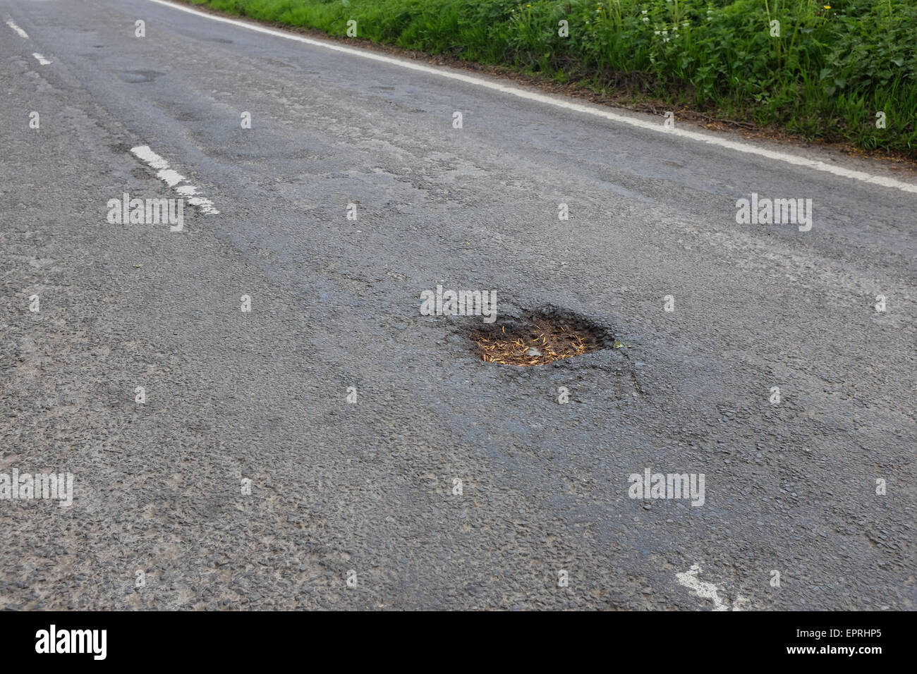 A road with a pothole Stock Photo - Alamy