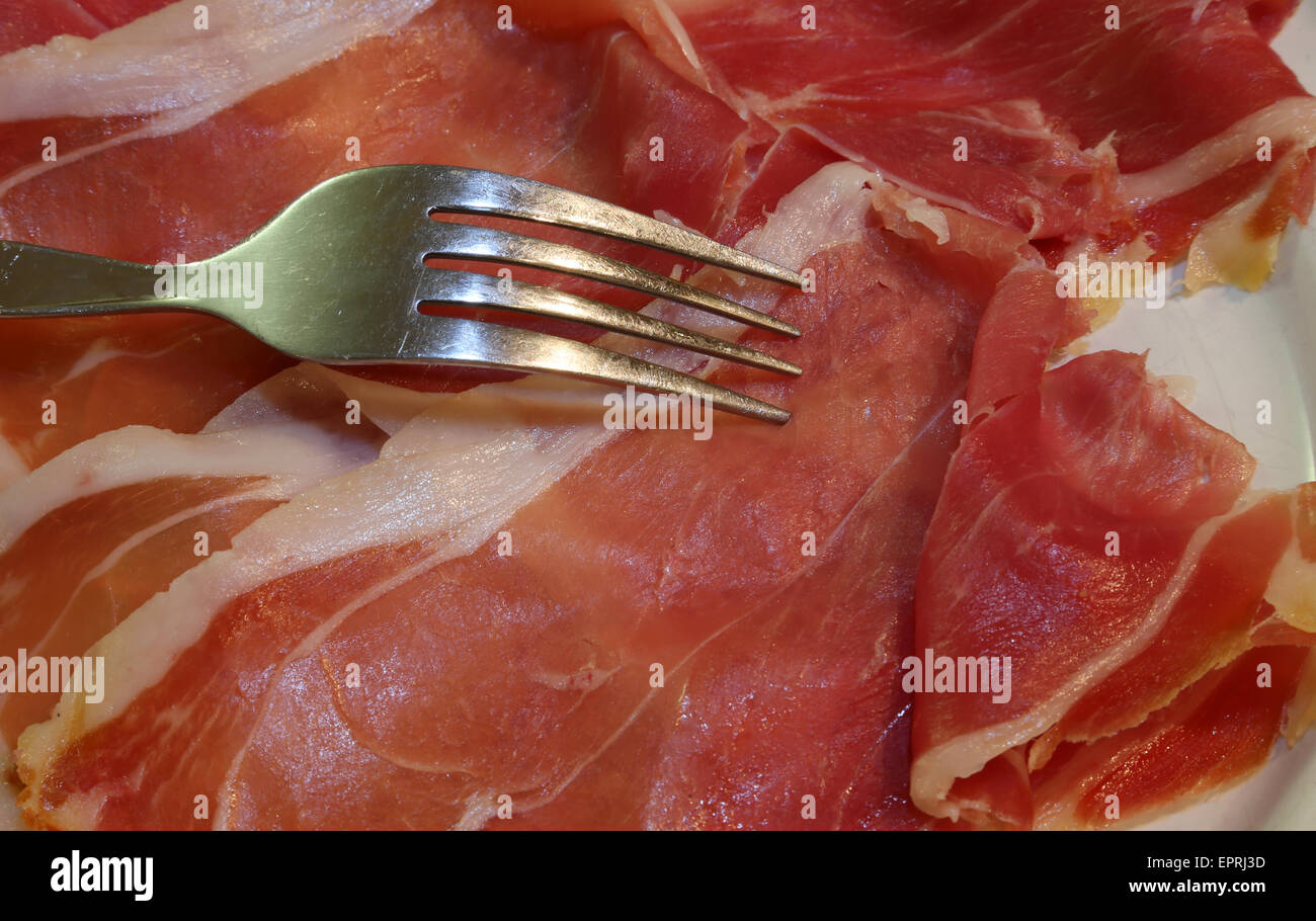 tasty slices of Italian raw ham and a fork Stock Photo - Alamy