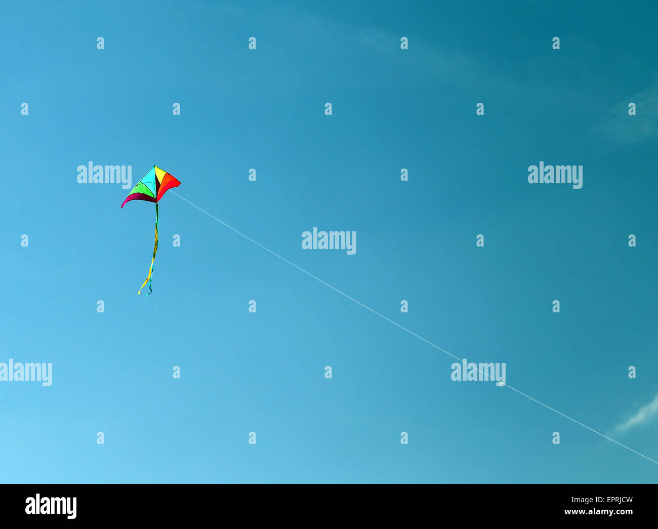 colorful kite flying high in the sky blue Stock Photo - Alamy