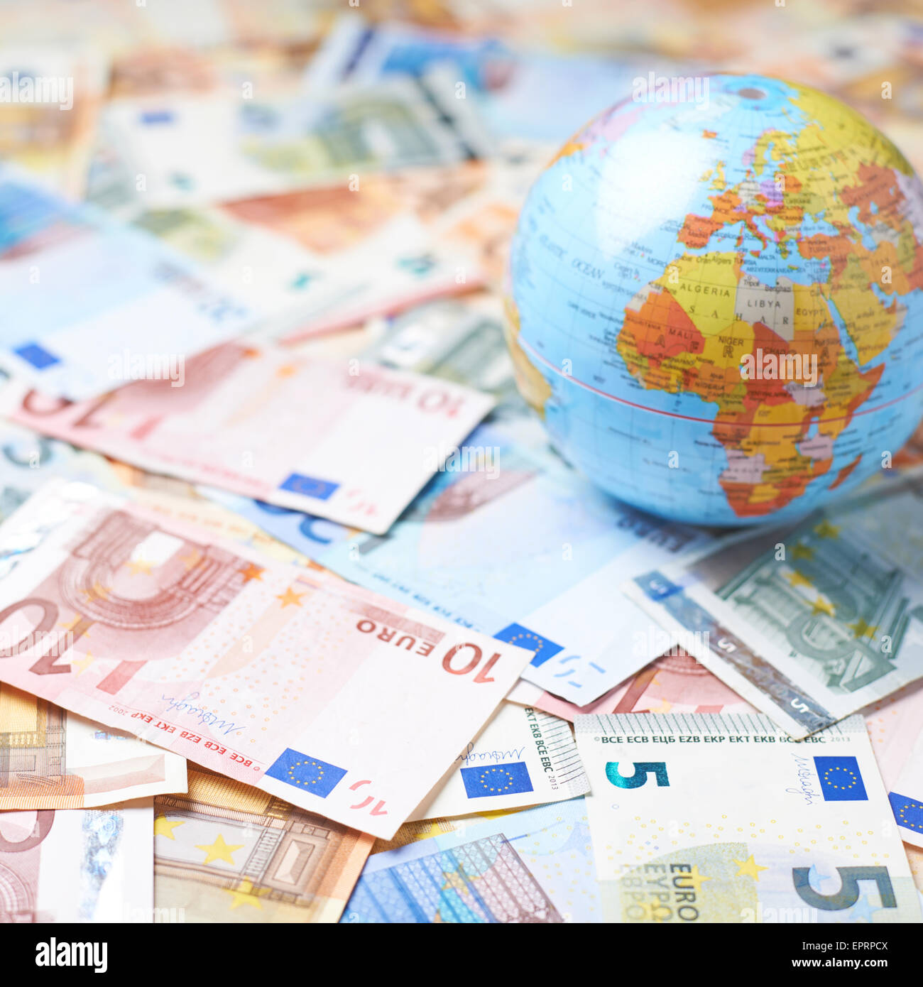 Earth globe over the pile of money Stock Photo - Alamy