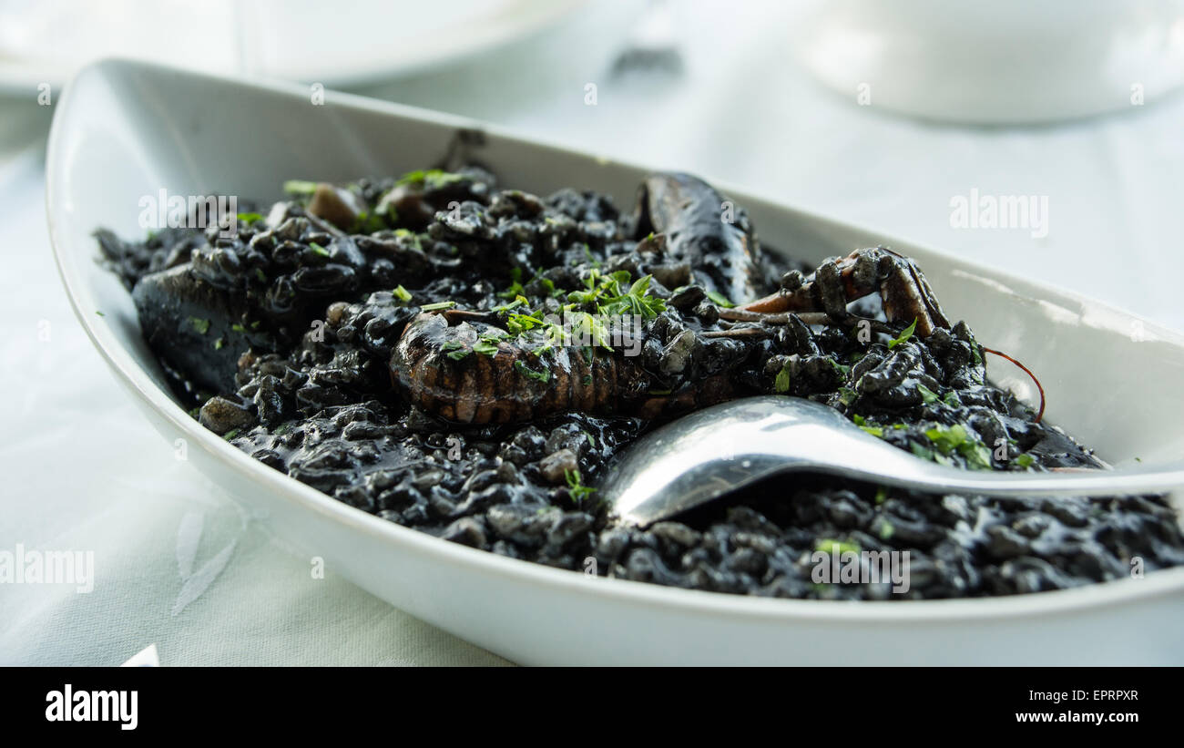 A plate of black risotto with seafood Stock Photo - Alamy