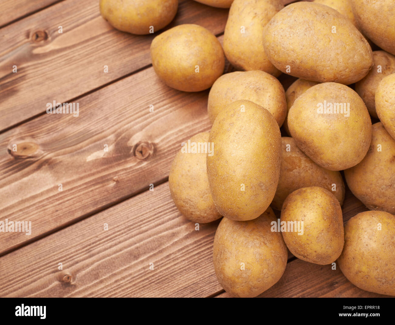 Pile of potatoes over the wooden surface Stock Photo - Alamy