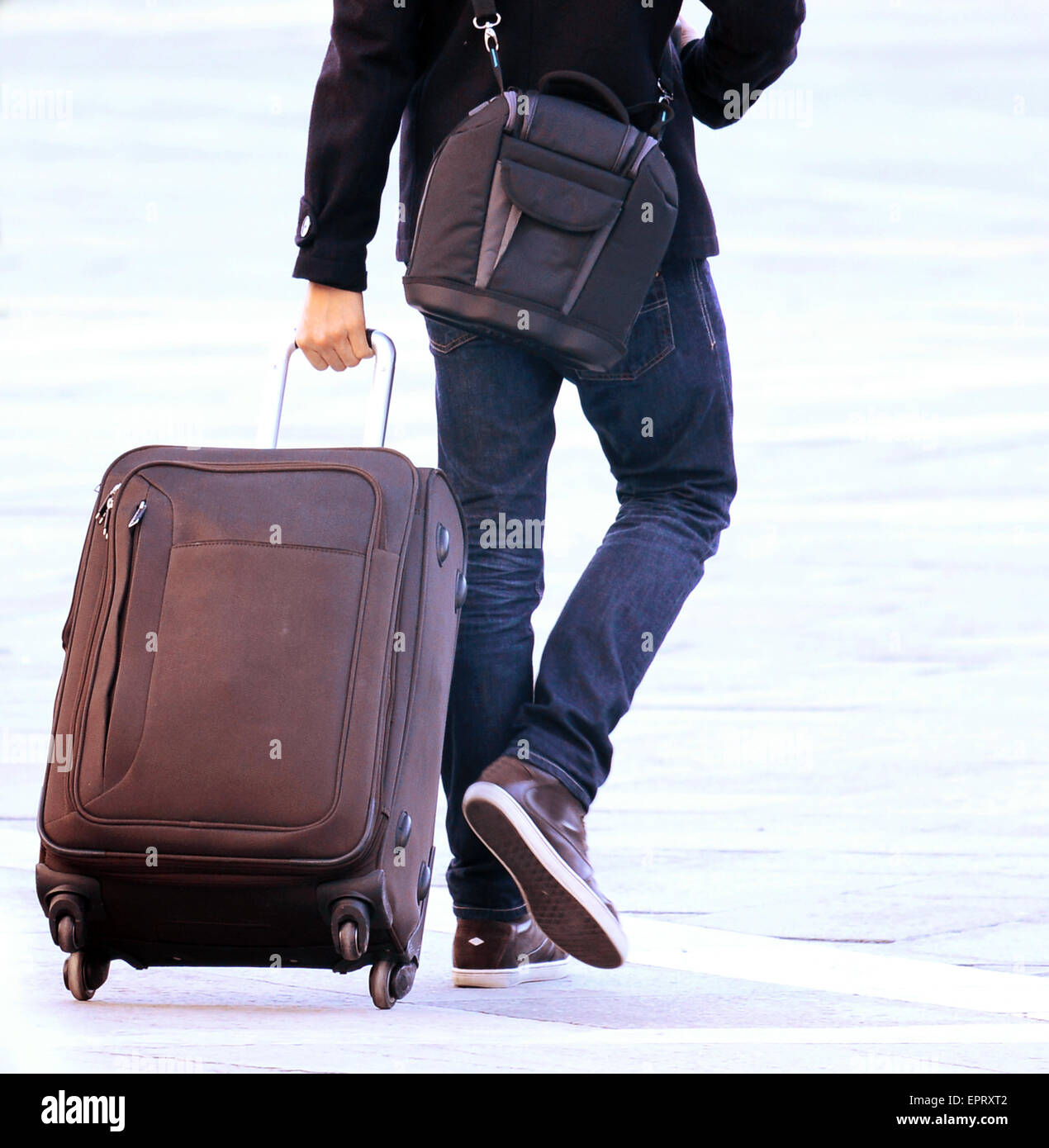 Traveler man walking with suitcase in the street Stock Photo - Alamy