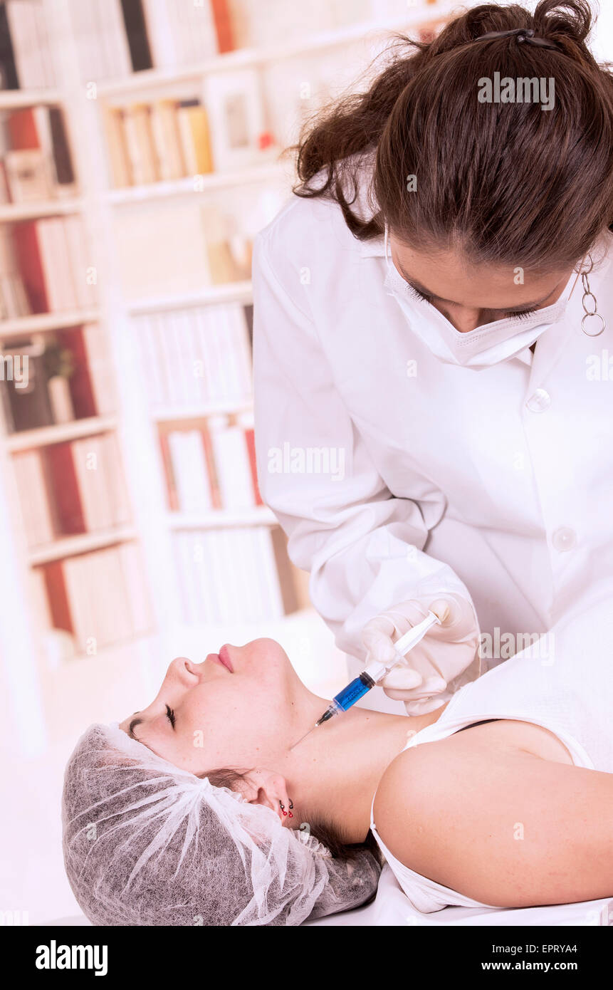 Young girl lying down ready to get a cosmetic injection in her face ...