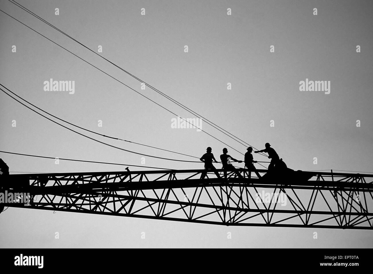 March 2000. Iron workers string massive steel cable on a crane boom to ...