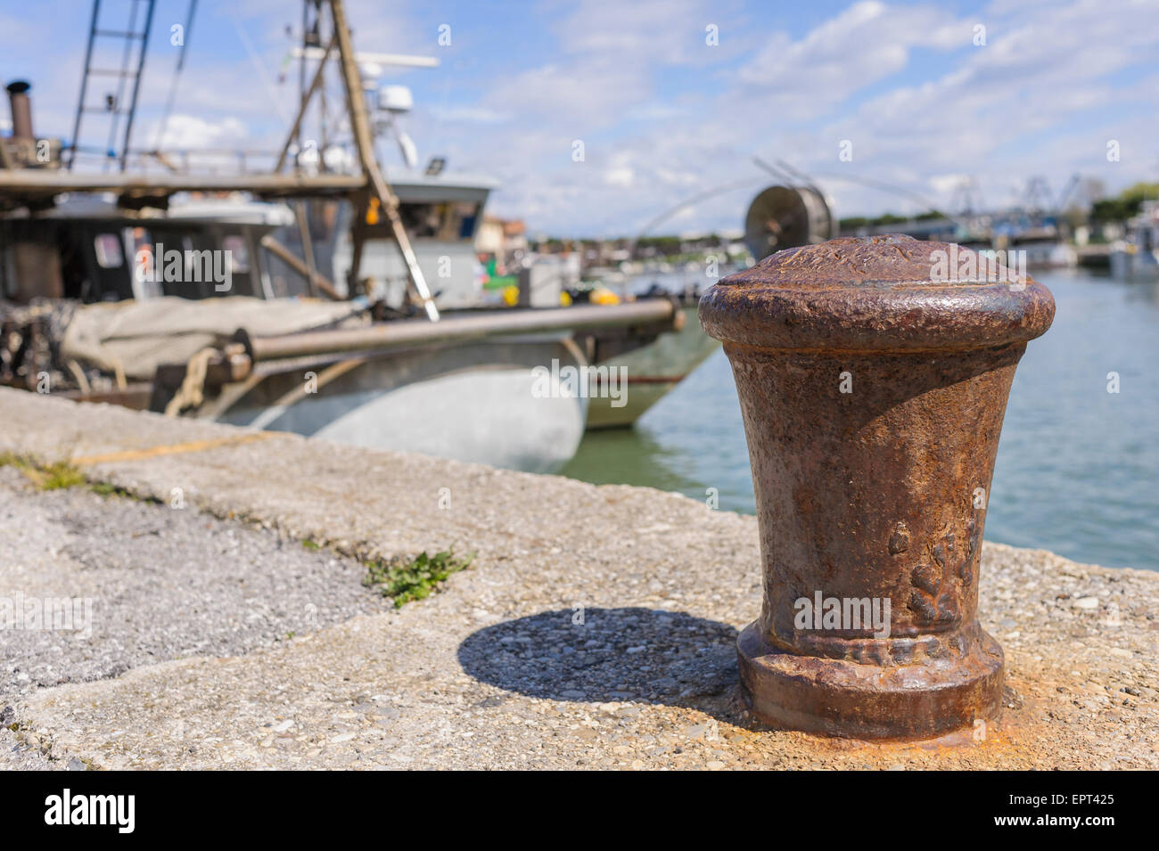 Mooring bollard in the harbor, with the background of fishing boats ...