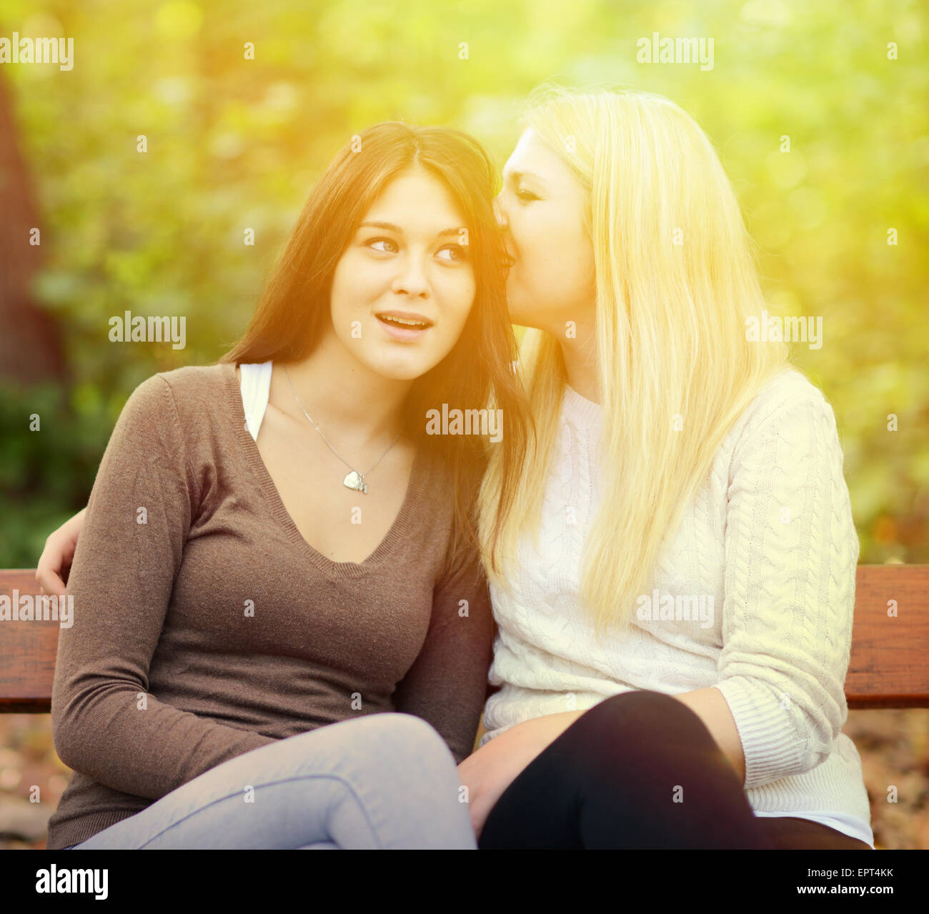 Two girl friends whispering secrets outdoors Stock Photo - Alamy