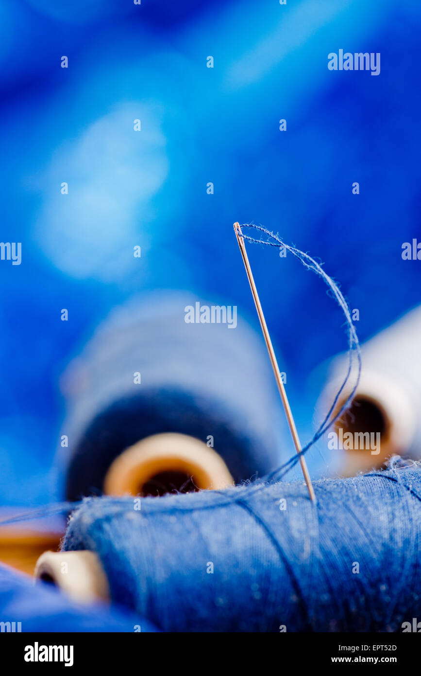 needle with blue thread on the blue background Stock Photo - Alamy