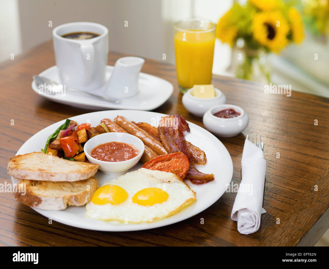 Breakfast of Fried Eggs, Bacon, Sausage, Vegetable Hash, Grilled Tomato, Toast, Coffee and Juice ...