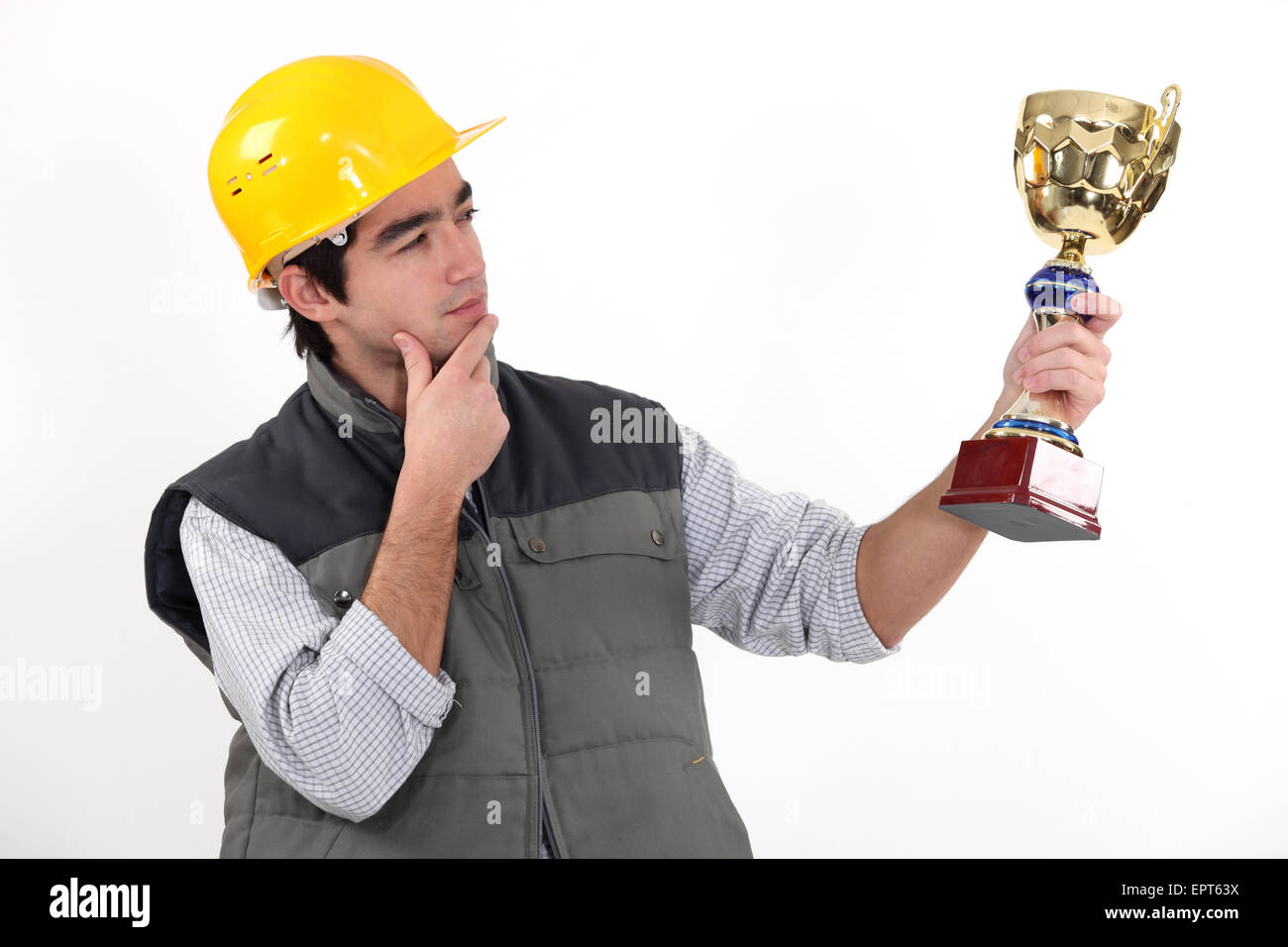 A construction worker holding a trophy Stock Photo - Alamy