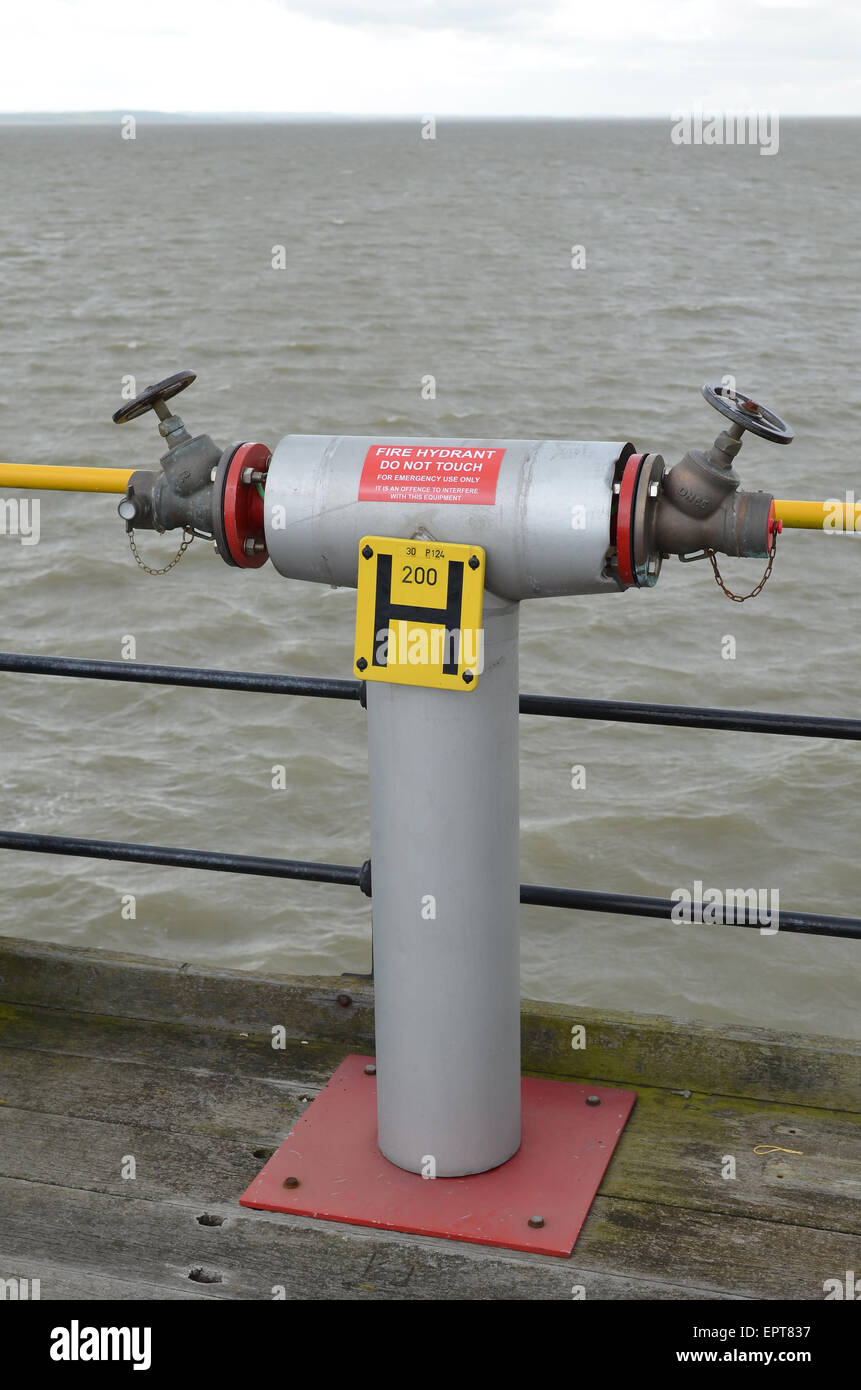 Twin outlet fire hydrant on wooden boardwalk beside the ocean Stock ...