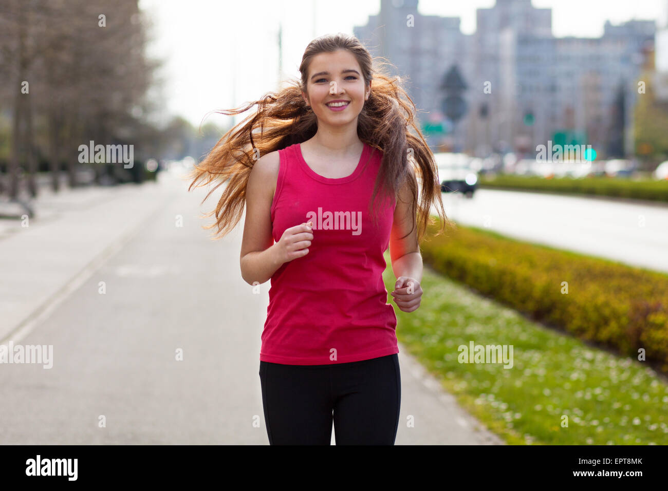 Young beautiful woman running in the city Stock Photo - Alamy