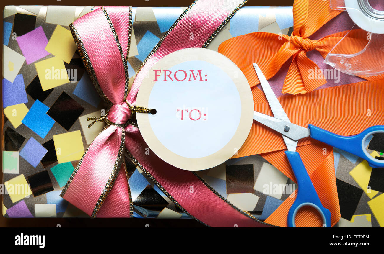 Wrapped present with scissors, tape and ribbon Stock Photo - Alamy