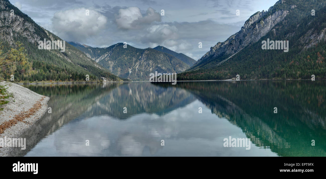 Scenic view of mountains reflected in a clear lake (Plansee) in autumn ...