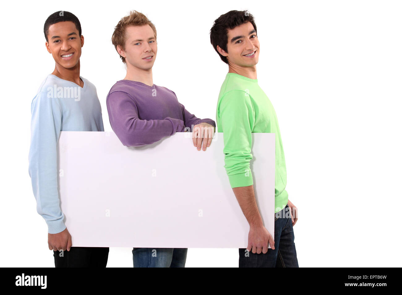 Three friends holding blank poster Stock Photo - Alamy