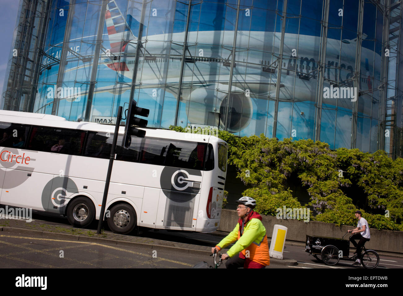 A tour coach drives beneath a large advert for American Airlines of a ...