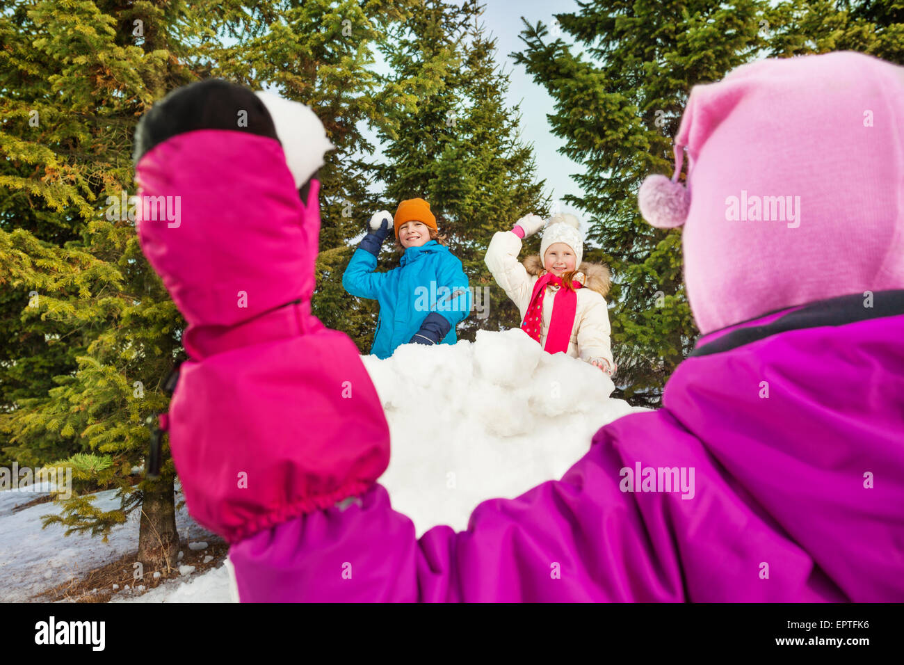 Girl throwing snowball from the back to throw Stock Photo - Alamy