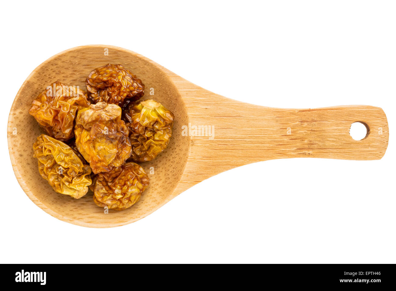 dried goldenberries on a small wooden spoon isolated on white with a ...