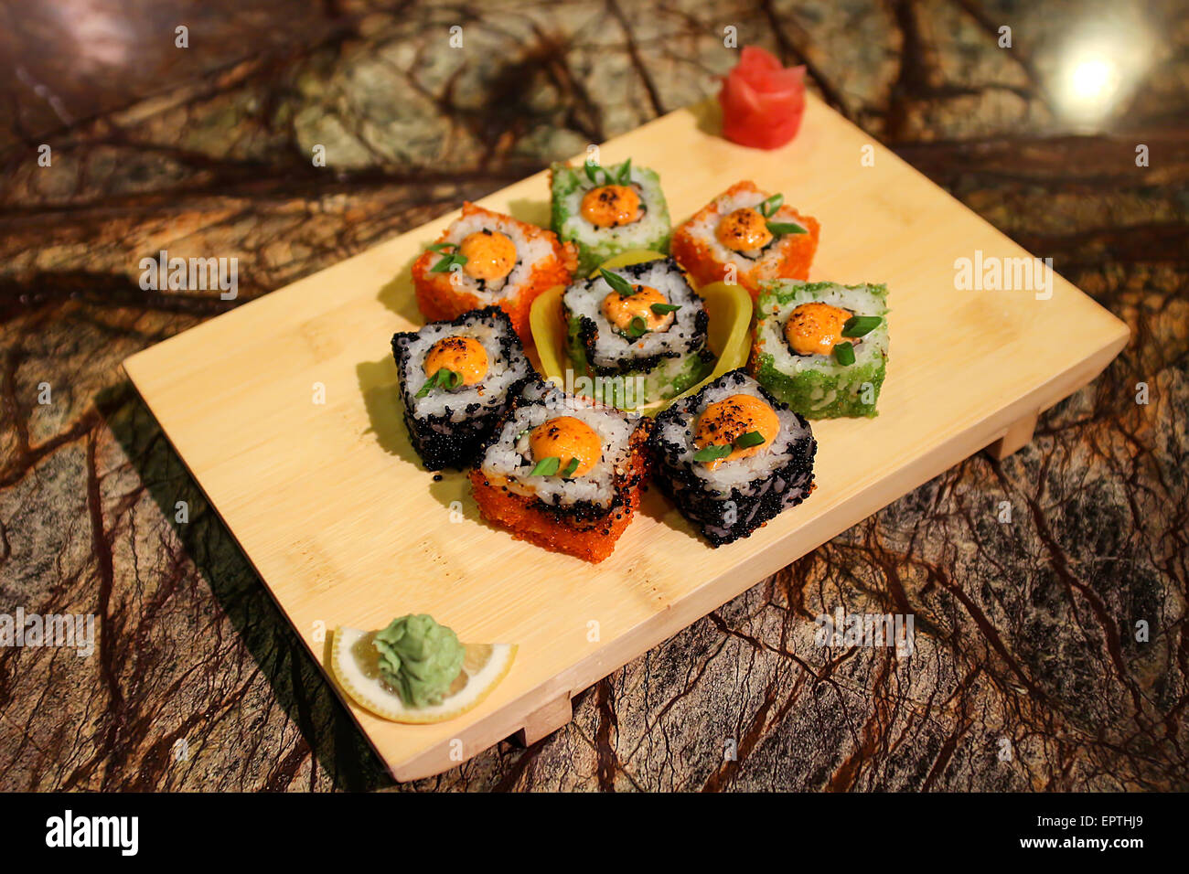 Delicious sauced Saka na maki sushi rolls served with a wood plate ...