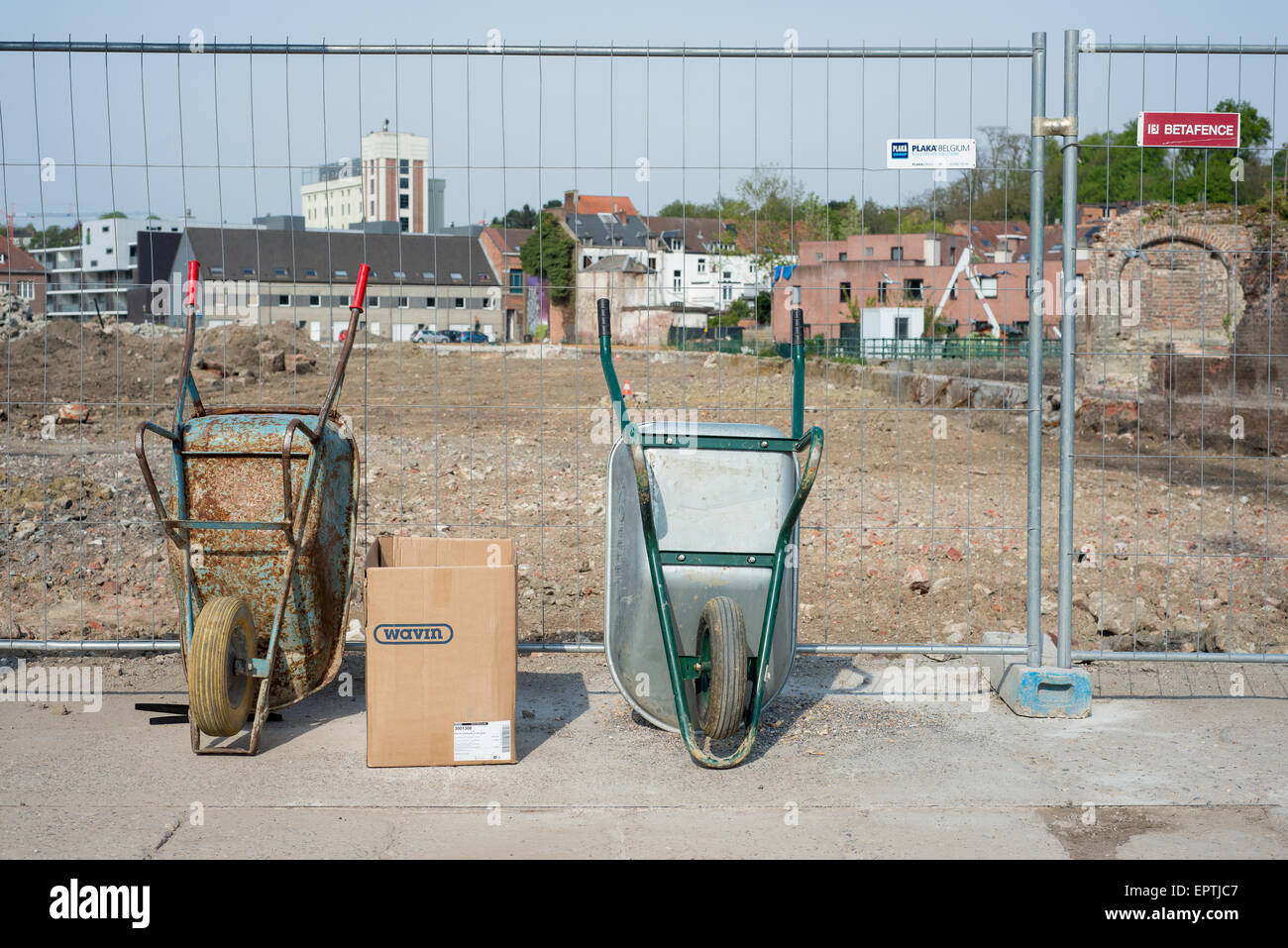 two wheel barrels against fence next to construction site Stock Photo ...